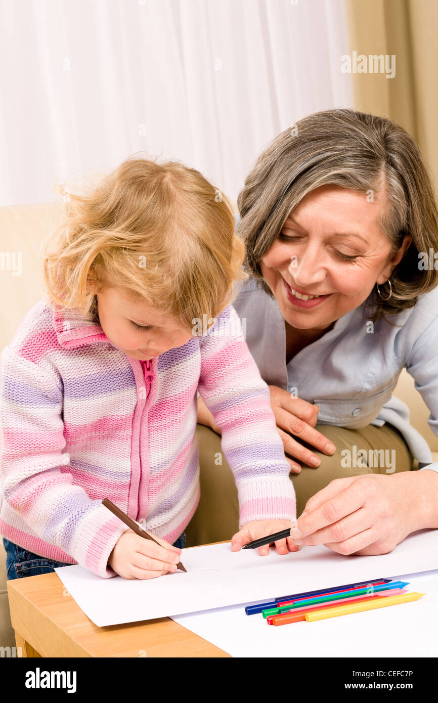 Grandmother and little girl drawing together with pencils at home Stock ...