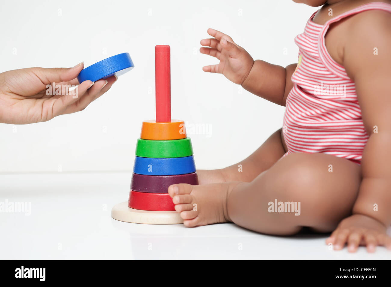 Mother's hand giving baby a piece of a wooden building toy Stock Photo ...