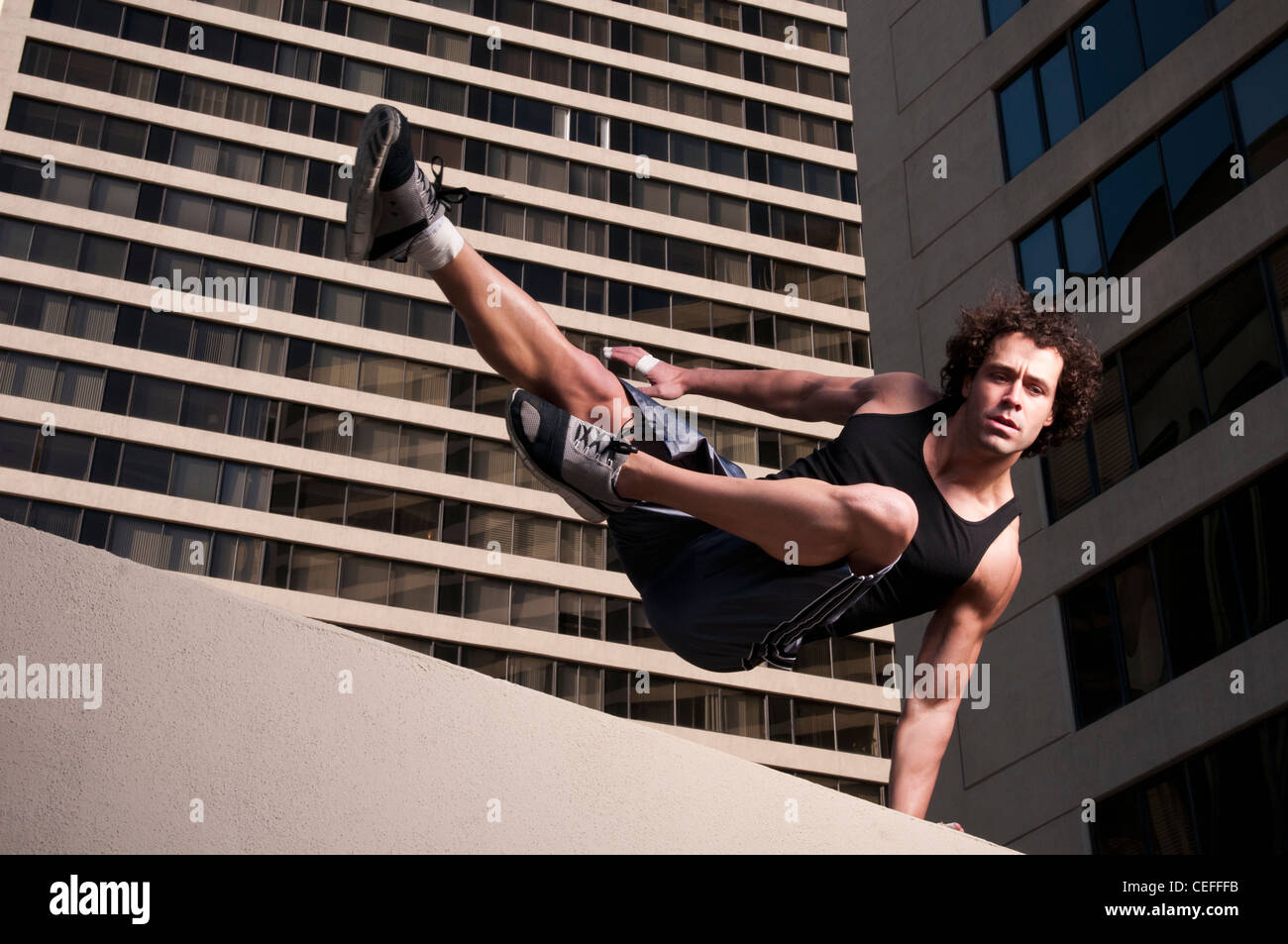 Athlete jumping over urban wall Stock Photo - Alamy