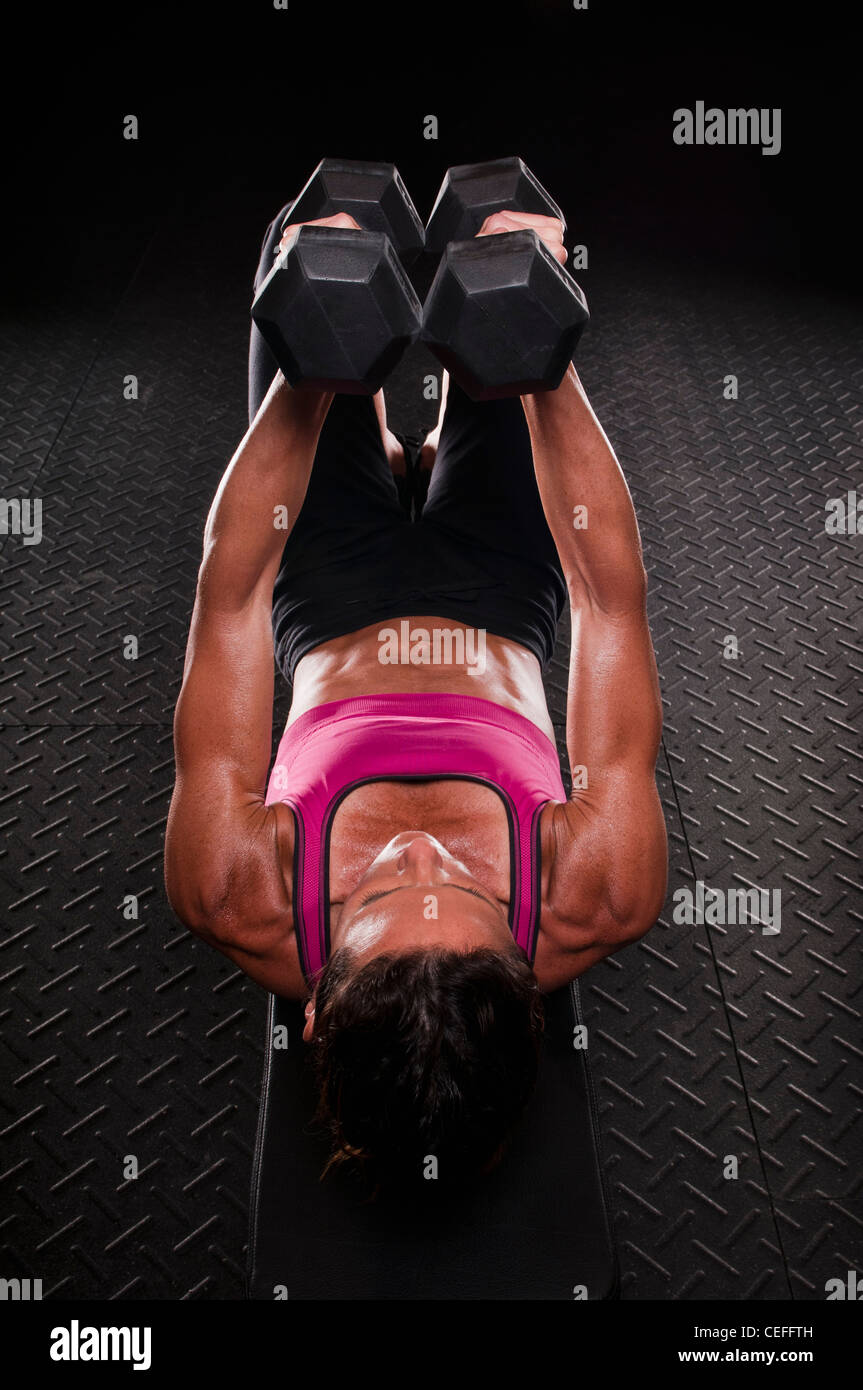 Woman lifting weights in gym Stock Photo - Alamy