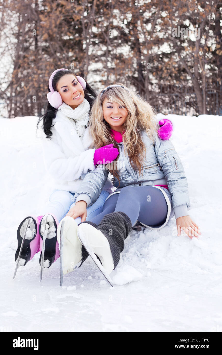 two beautiful girls ice skating outdoor on a warm winter day (focus on ...