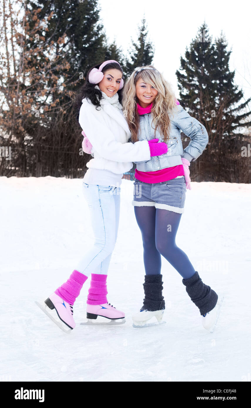 two happy young women ice skating outdoor on a winter day Stock Photo ...