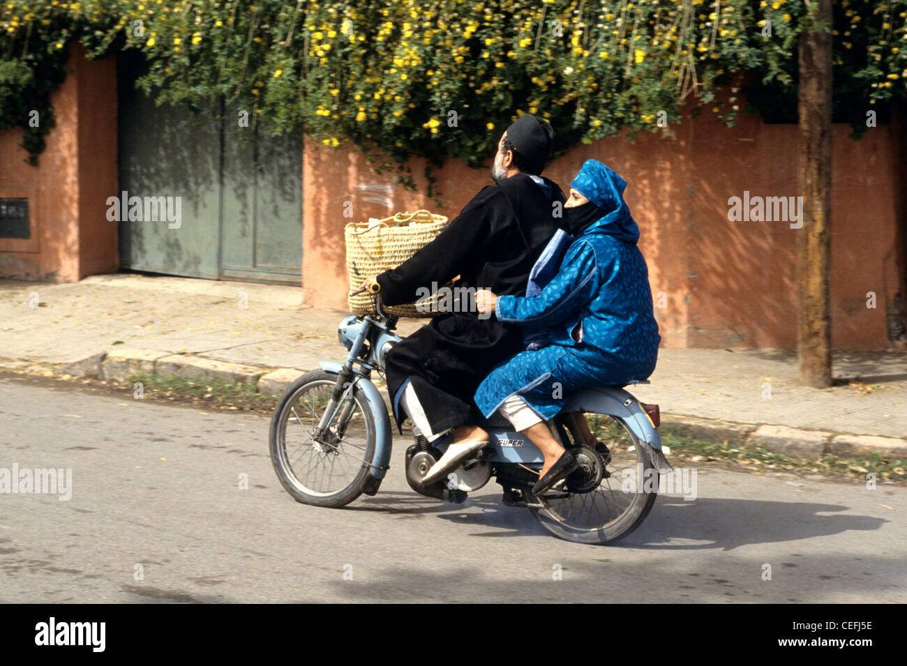 Marocco- Husband an wife share a moped Stock Photo - Alamy