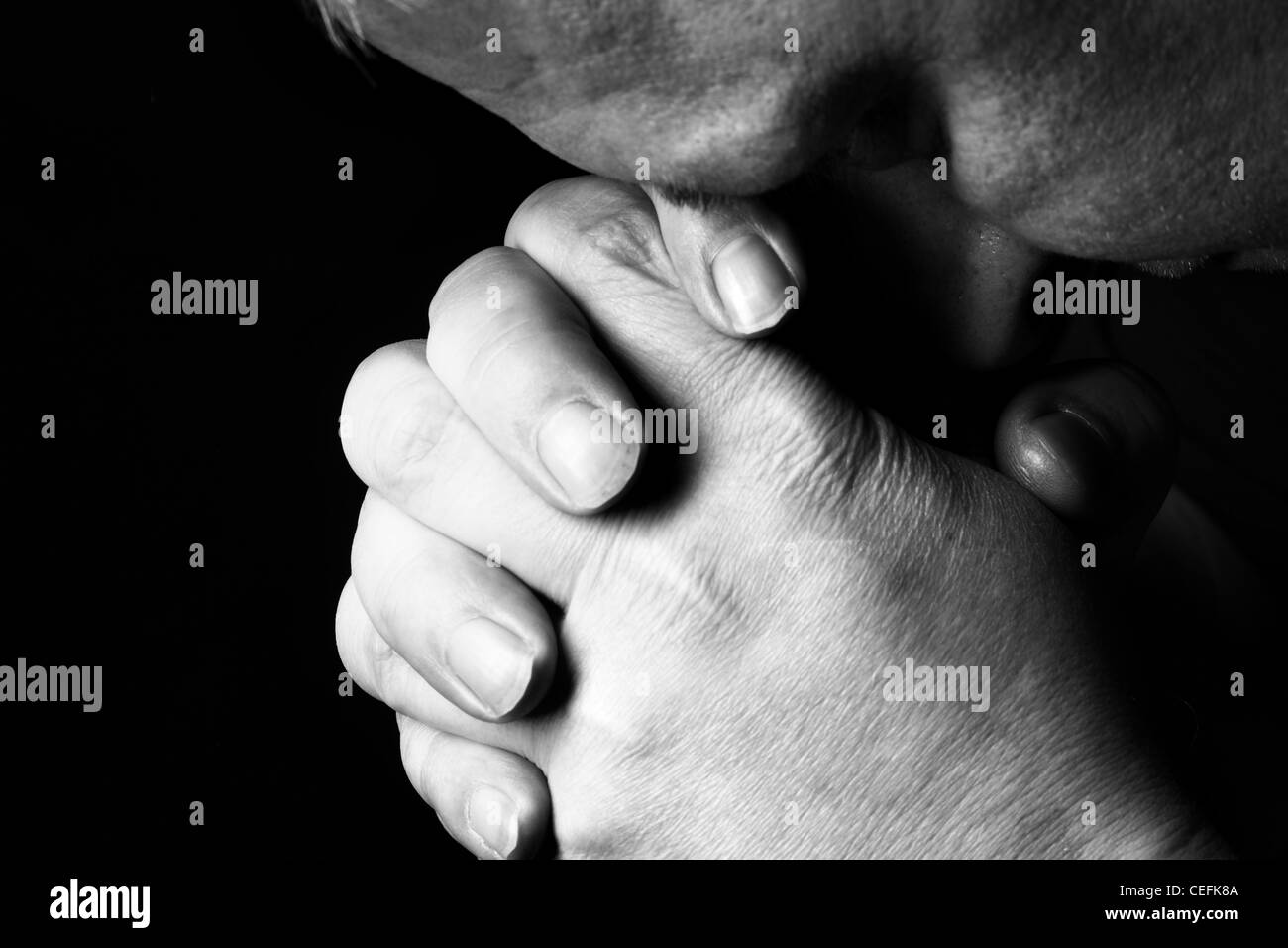 Man pray for something over the black background Stock Photo - Alamy