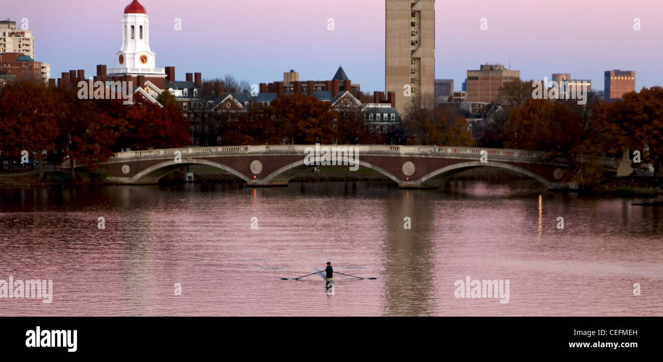 A lone rower on the Charles River with parts of Harvard University with ...