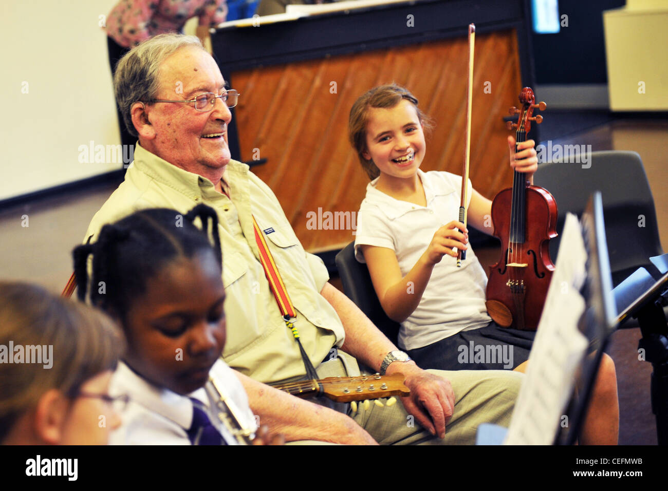 Intergenerational orchestra, young and old play music together in a ...