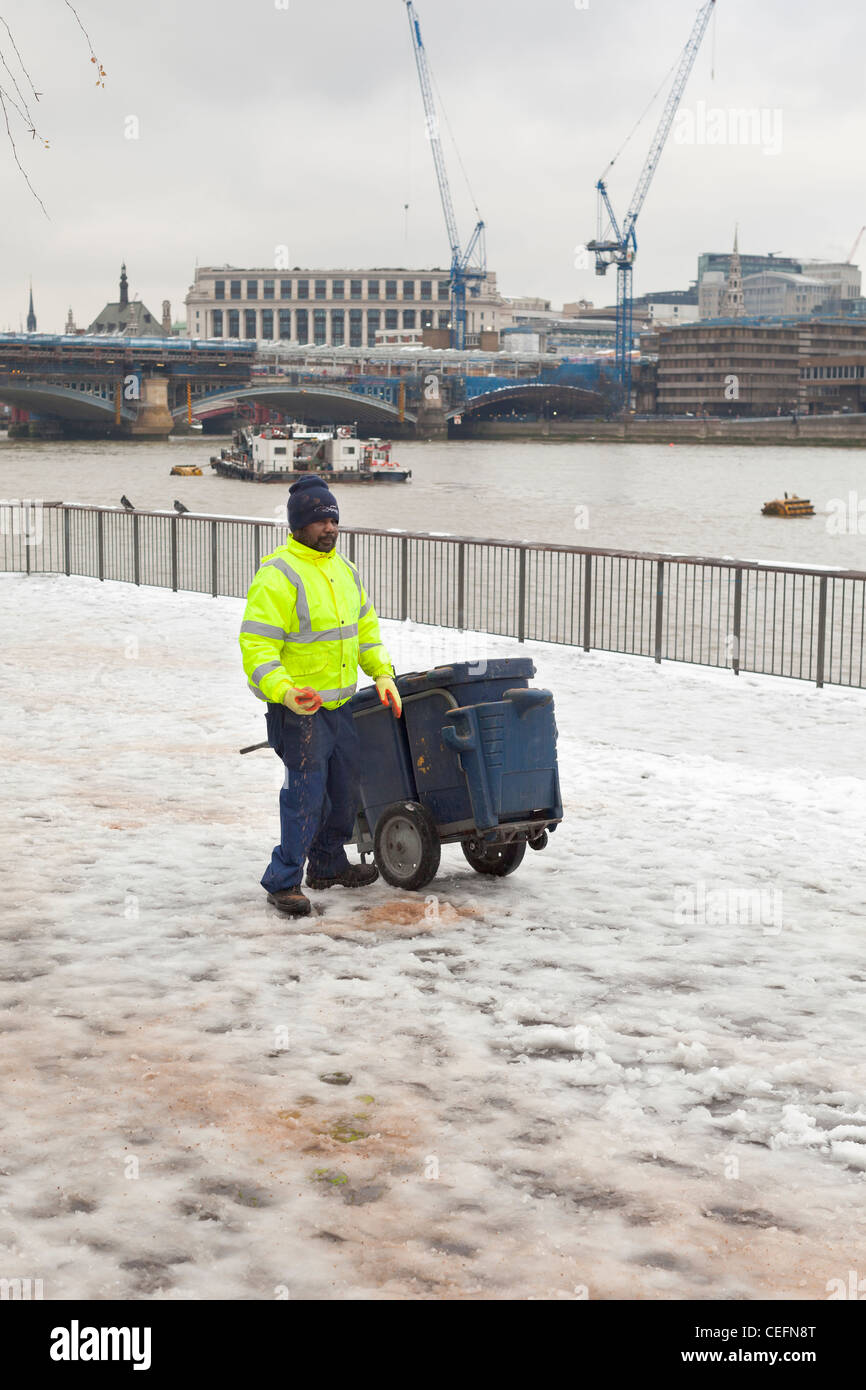 Council worker gritting the pavement, London, UK Stock Photo - Alamy
