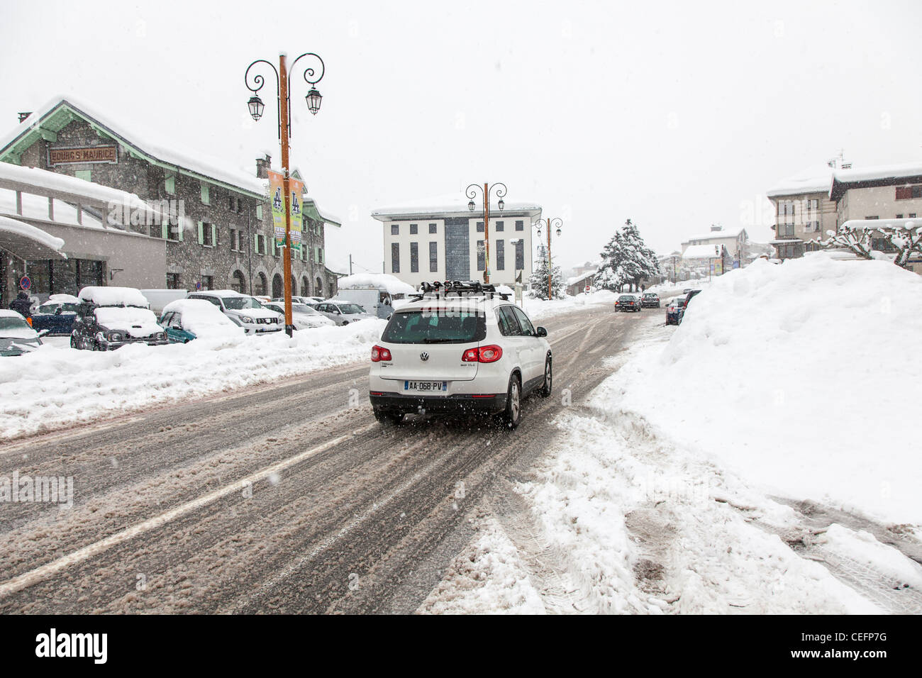 Cars driving along a road in bad snowing weather conditions, Bourg St ...