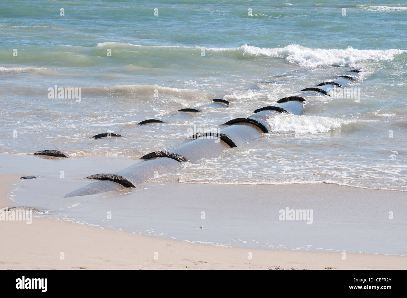 Water outlet pipes stretch into the sea at Strand, Western Cape South ...