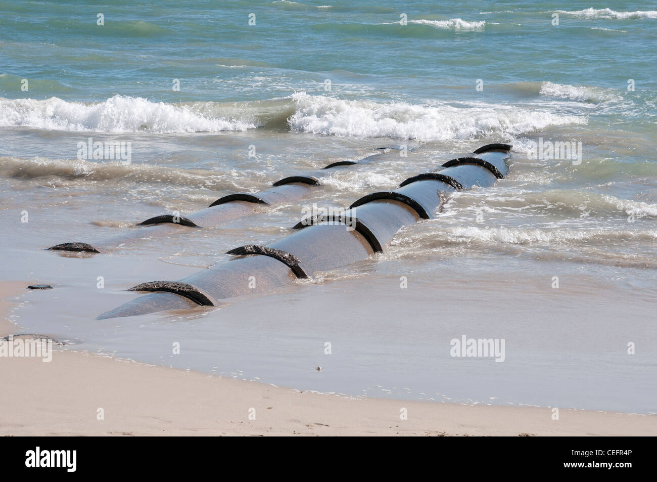 Water outlet pipes stretch into the sea at Strand, Western Cape South ...