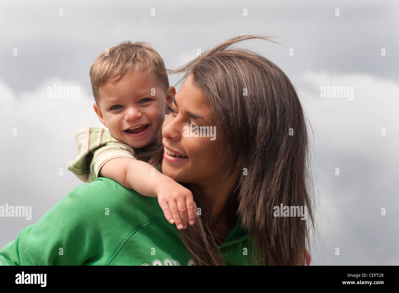 happy young woman giving child piggyback ride Stock Photo - Alamy