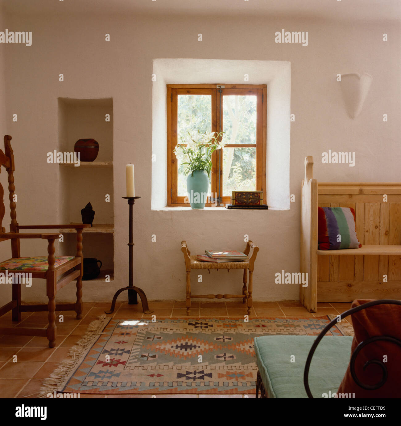 Kelim rug on floor below window in simple Majorcan living room with ...