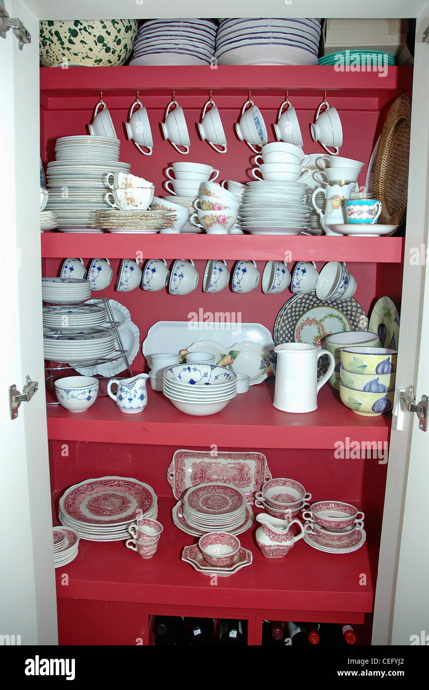 Close-up of pink+white Spode china with assorted cups and plates on red ...