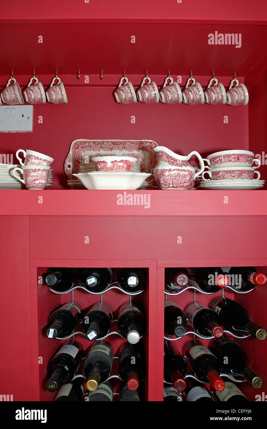 Close-up of collection pink+white Spode china on hooks and cupboard ...