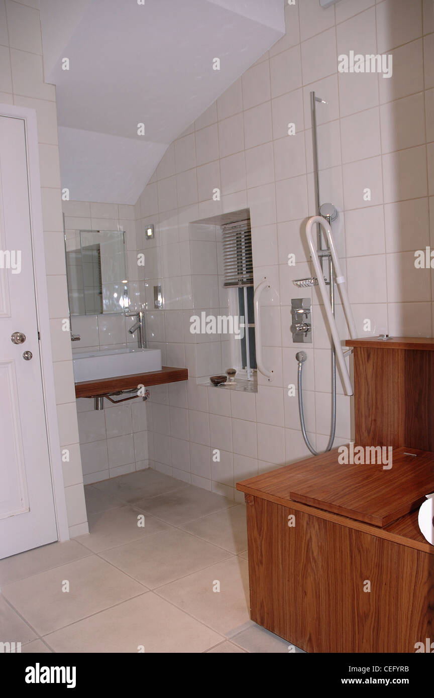 Limestone floor tiles and teak paneling concealing toilet in modern ...