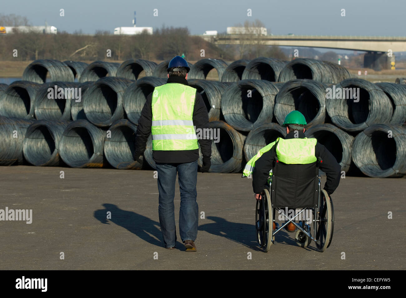 Rear view of male colleagues looking at cable wire construction site ...