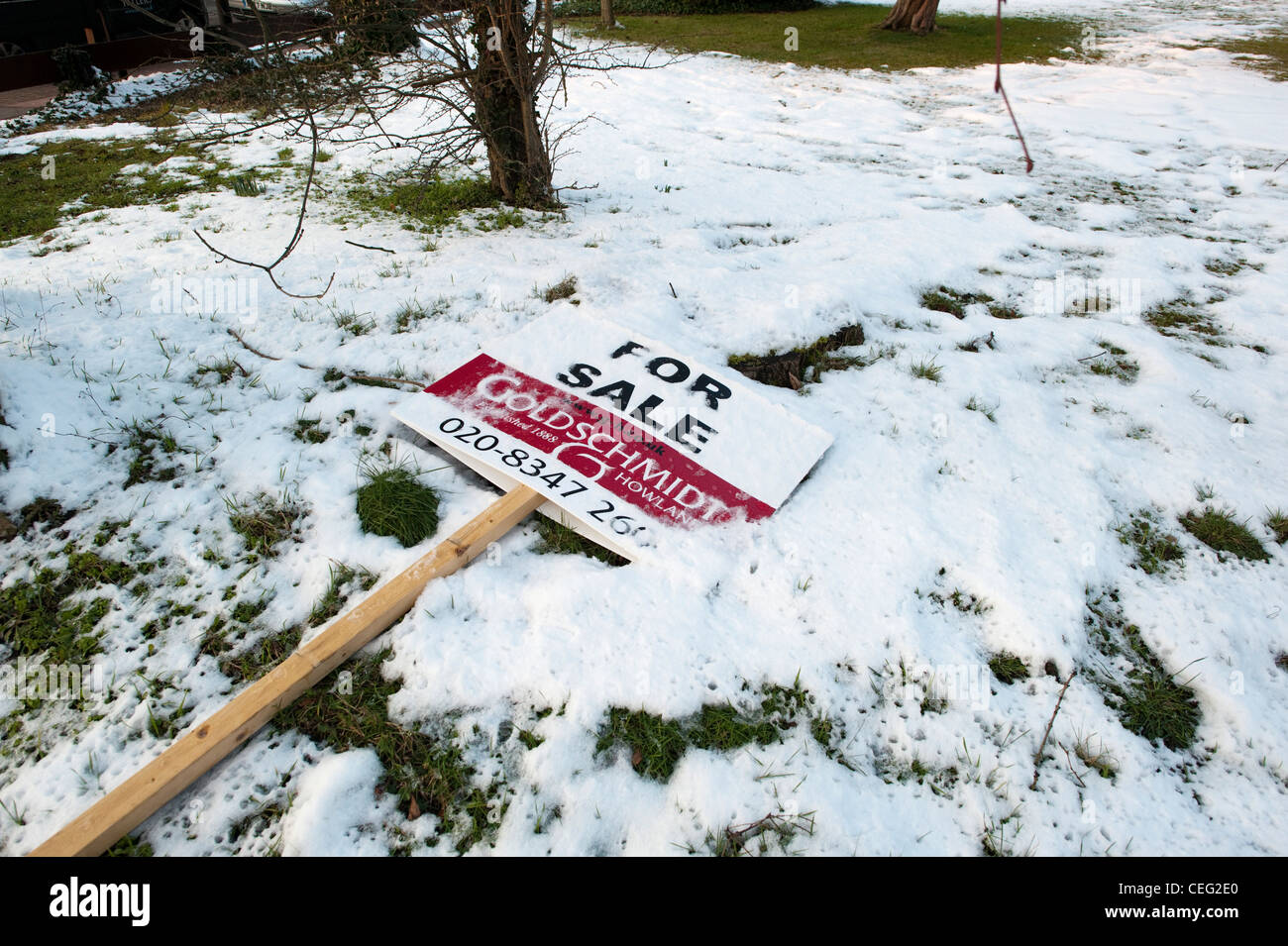For sale sign fallen over in the snow Stock Photo - Alamy