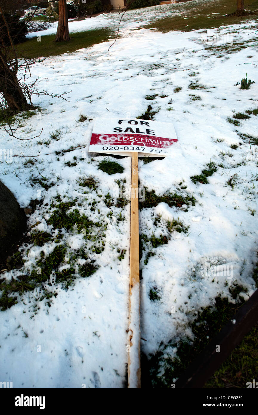For sale sign fallen over in the snow Stock Photo - Alamy