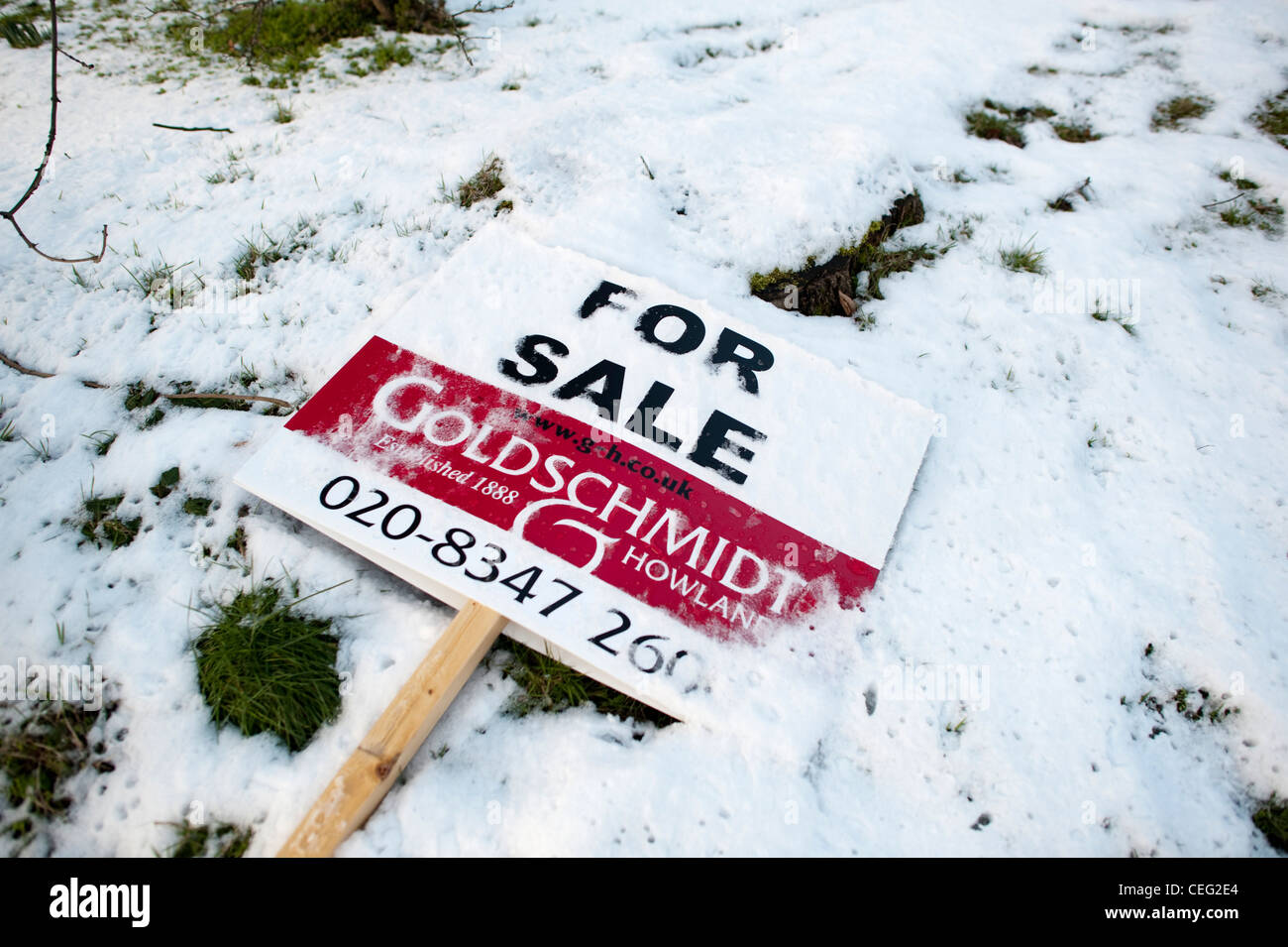 For sale sign fallen over in the snow Stock Photo - Alamy