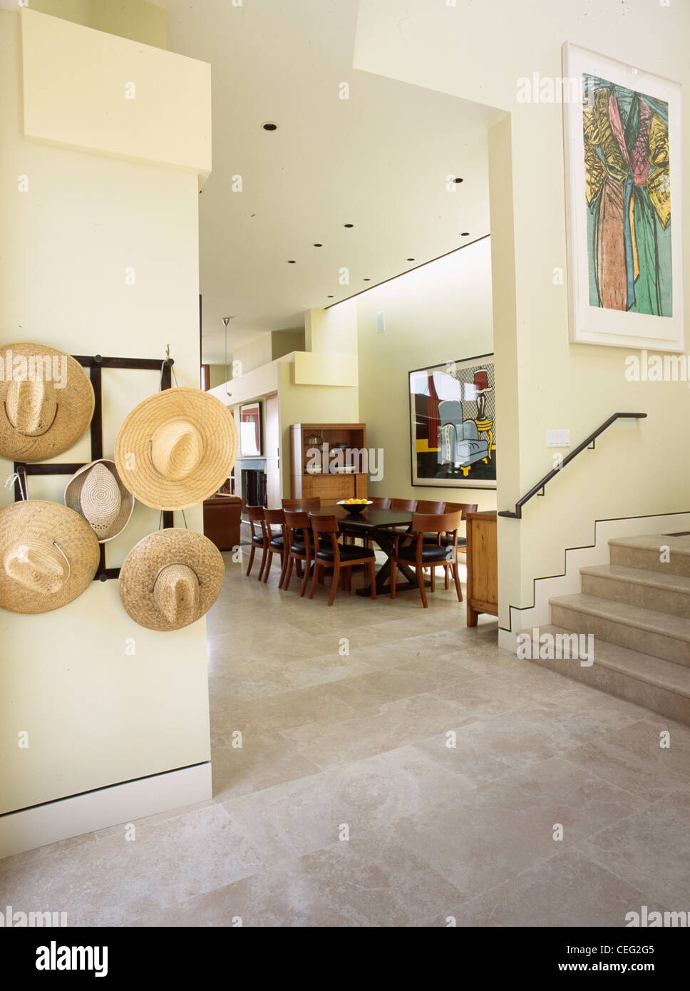 Straw hats on wall in modern open-plan hall with tiled flooring and ...
