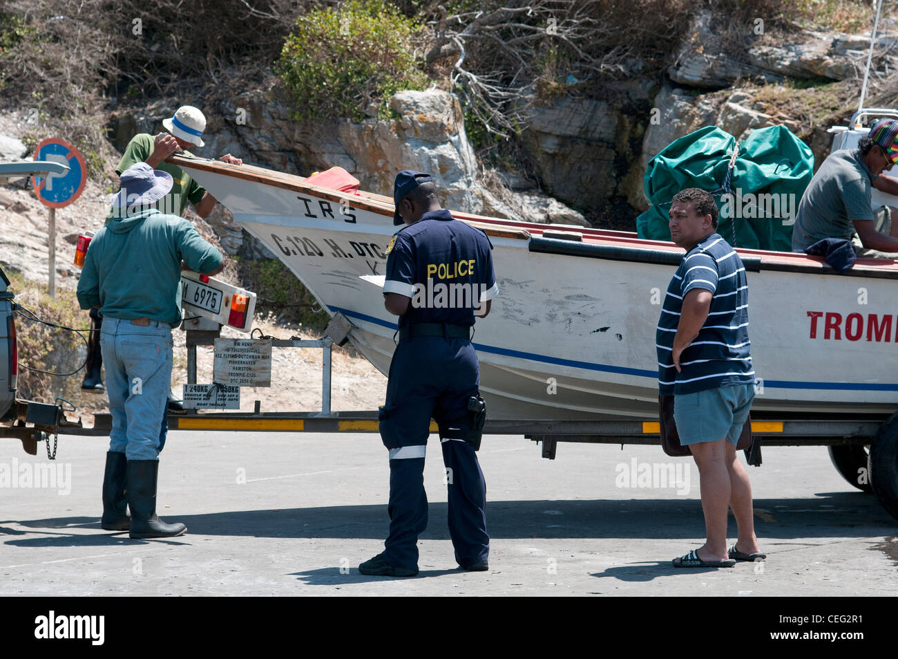 Police officer checking the size of a fishing boats' catch. New Harbour ...
