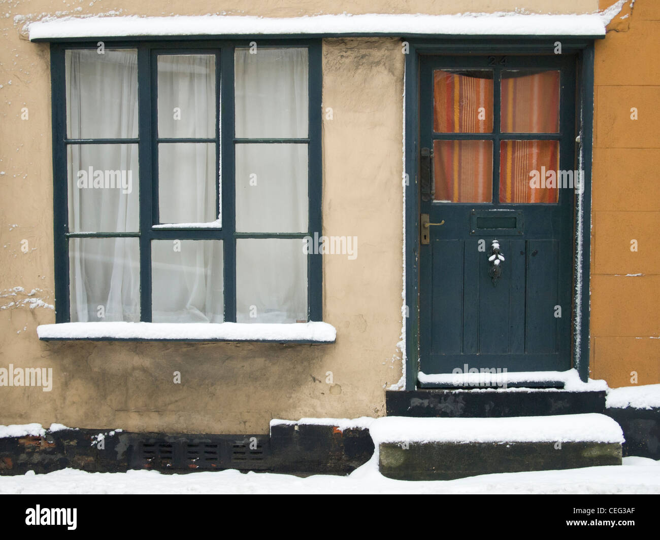 A front door and window of a small house in winter, with snow Stock ...
