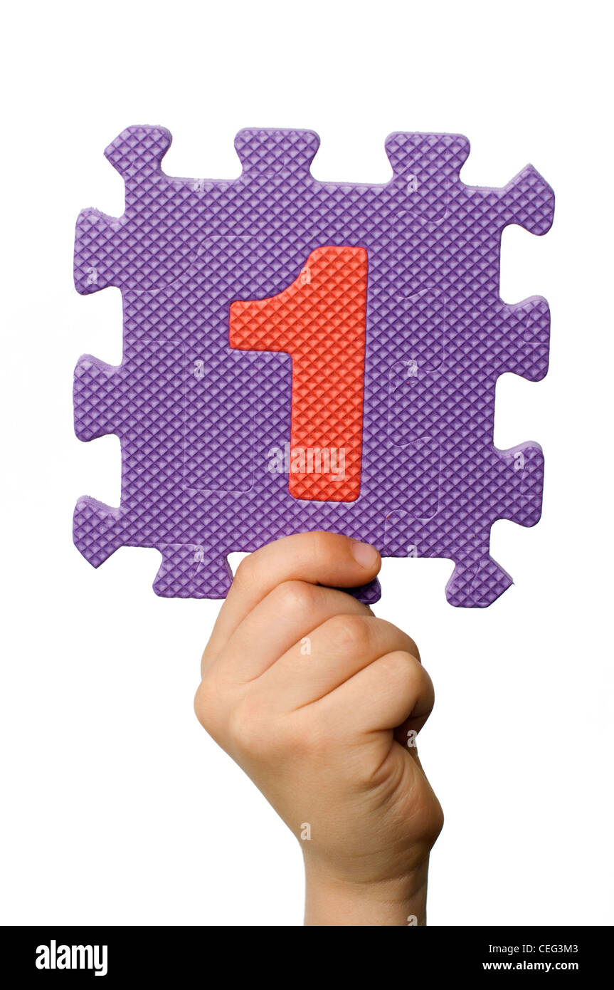 Children hand holding the number One. White isolated multicolor number ...