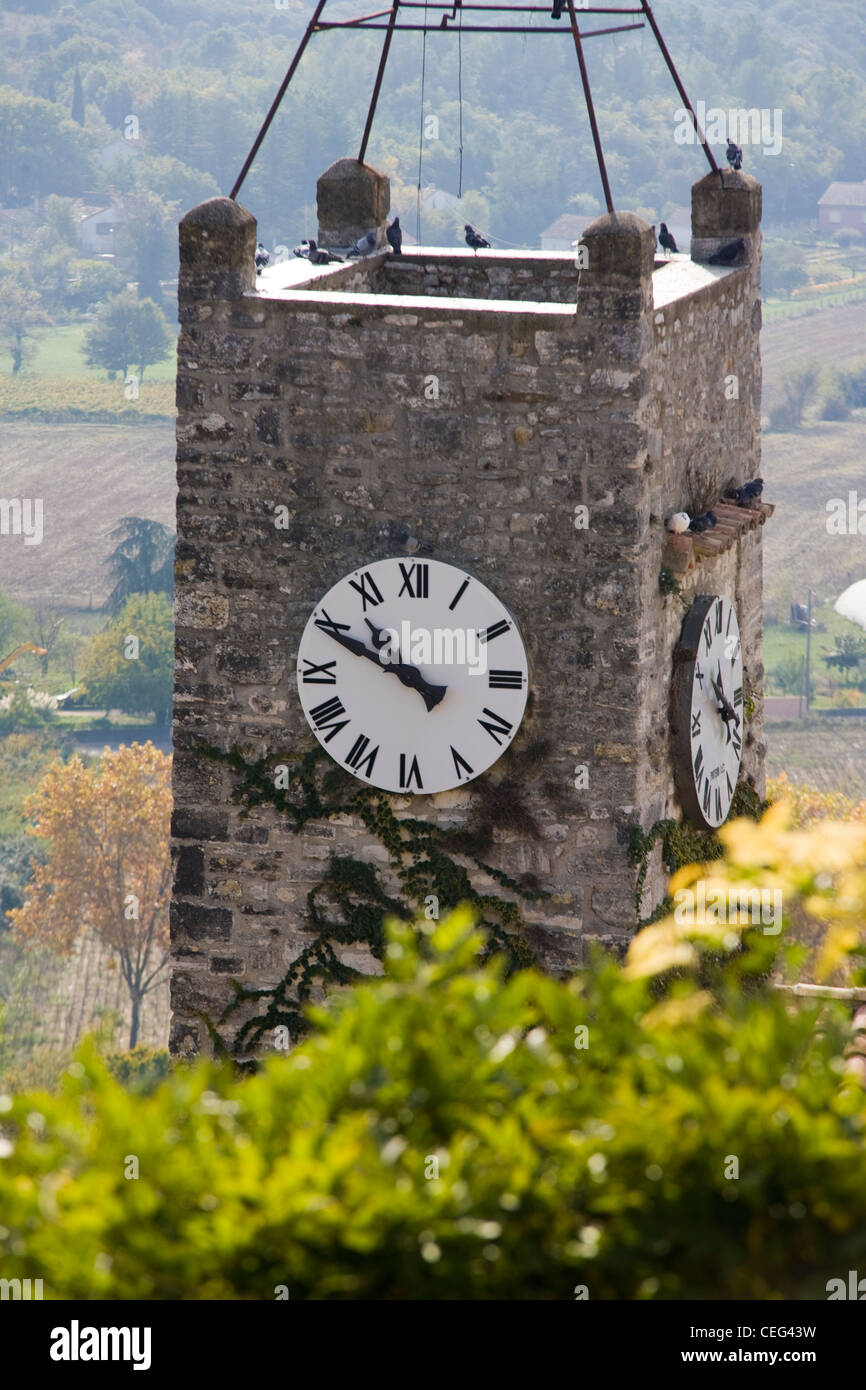 The clock tower and church in the centre of Vezenobres, Gard, France ...