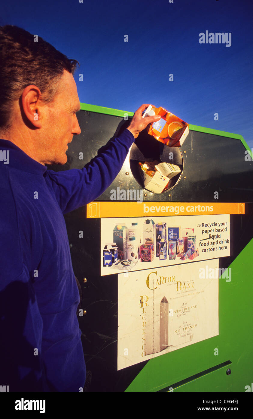 man putting drinks carton into recycling bin uk Stock Photo - Alamy
