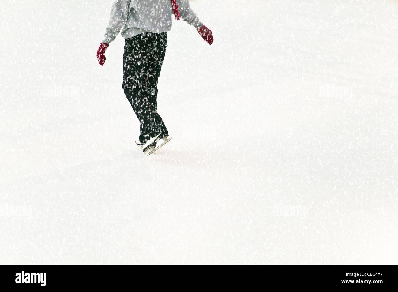 Young Caucasian woman ice skating while it is snowing Stock Photo - Alamy