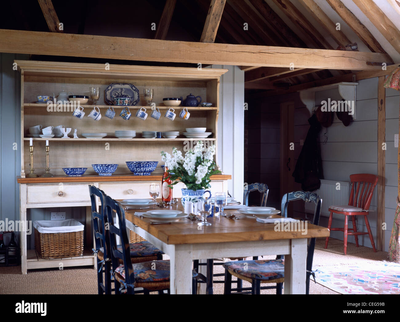 Simple wood table and chairs in converted oast house dining room with ...