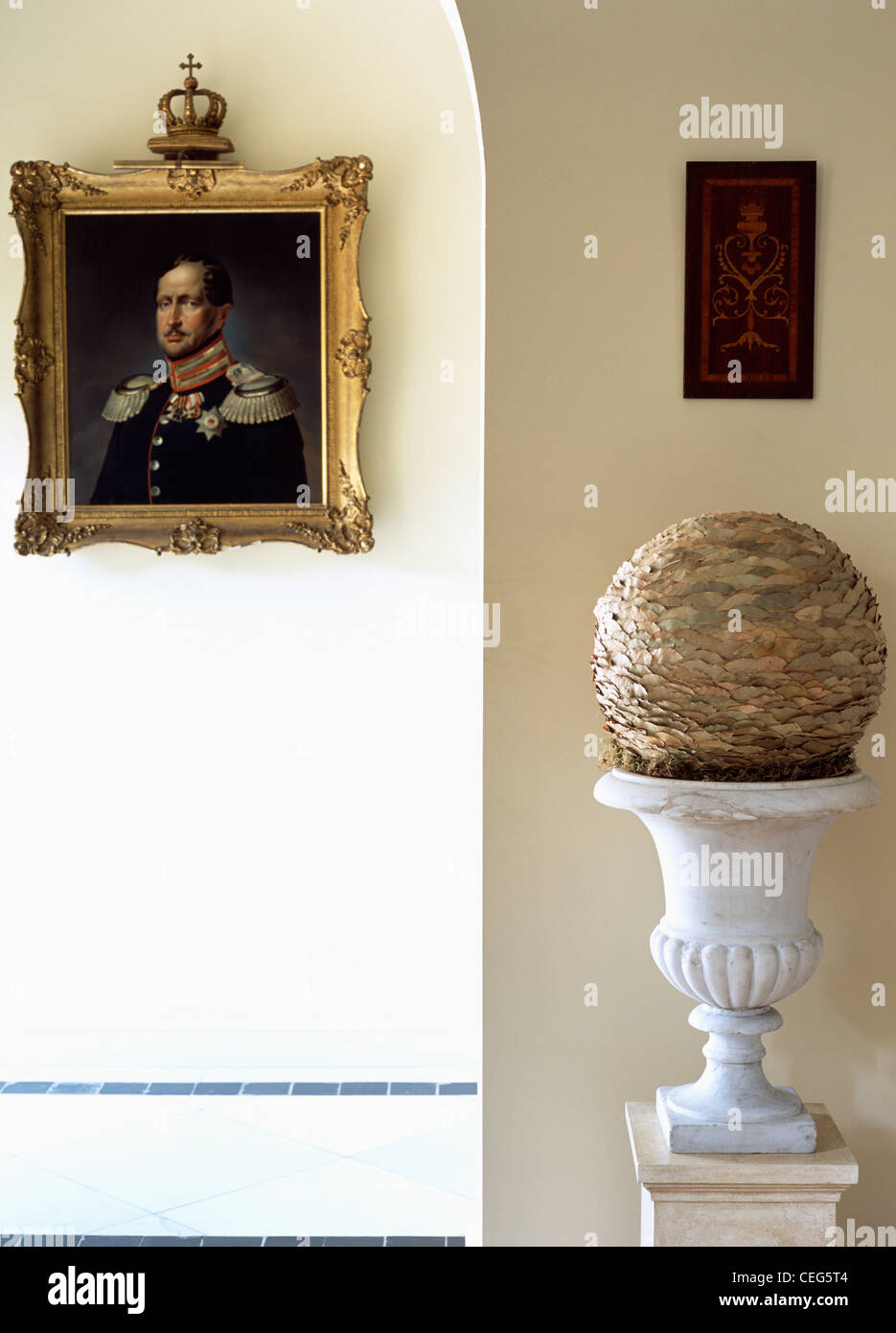 Large textured sculptural ball on stone plinth beside archway with view ...