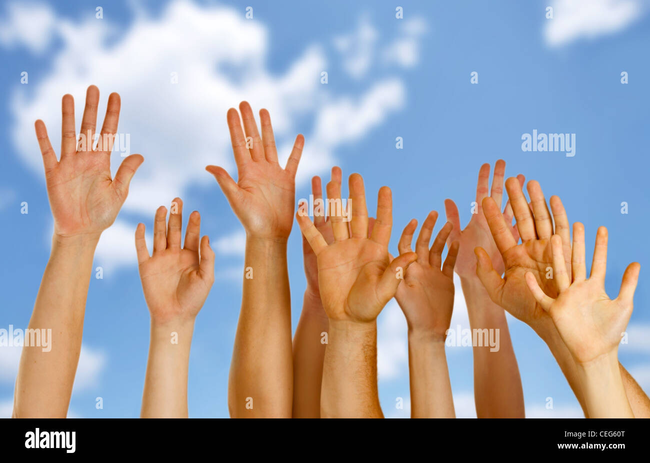 Hands raised up in air across blue sky Stock Photo - Alamy