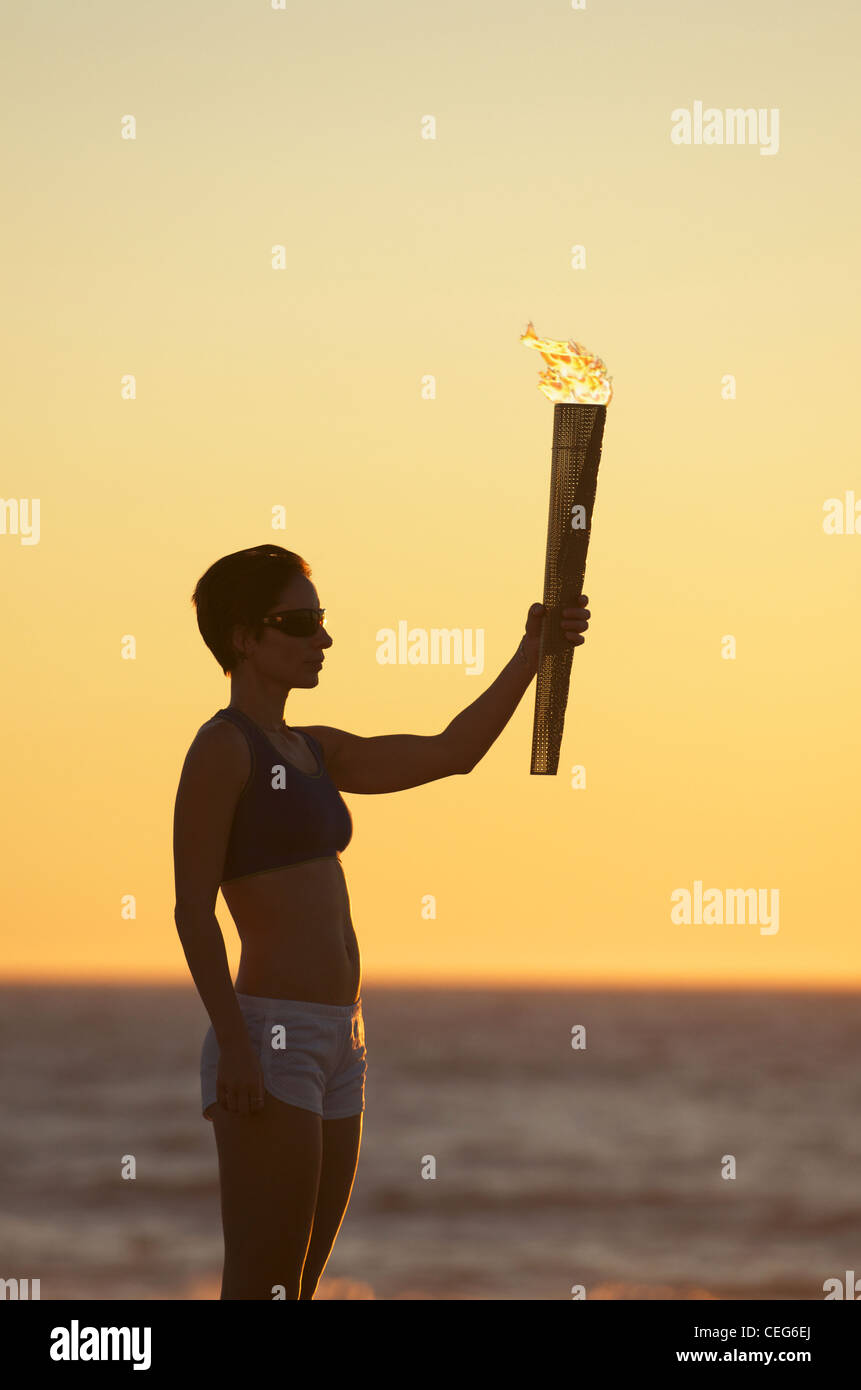 A portrait of a silhouetted woman holding a simulated olympics relay ...