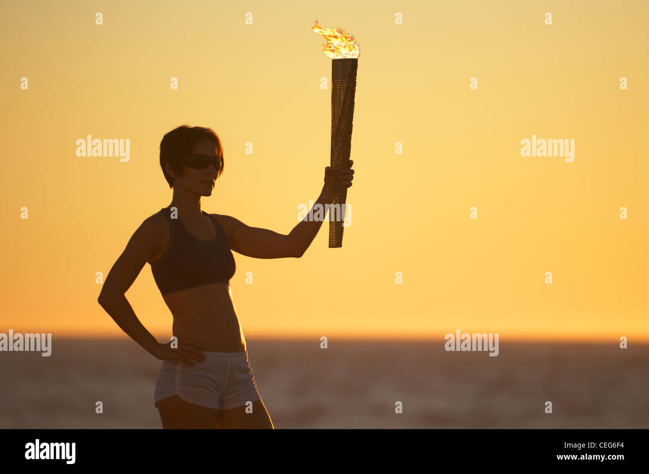 A portrait of a silhouetted woman holding a simulated olympics relay ...