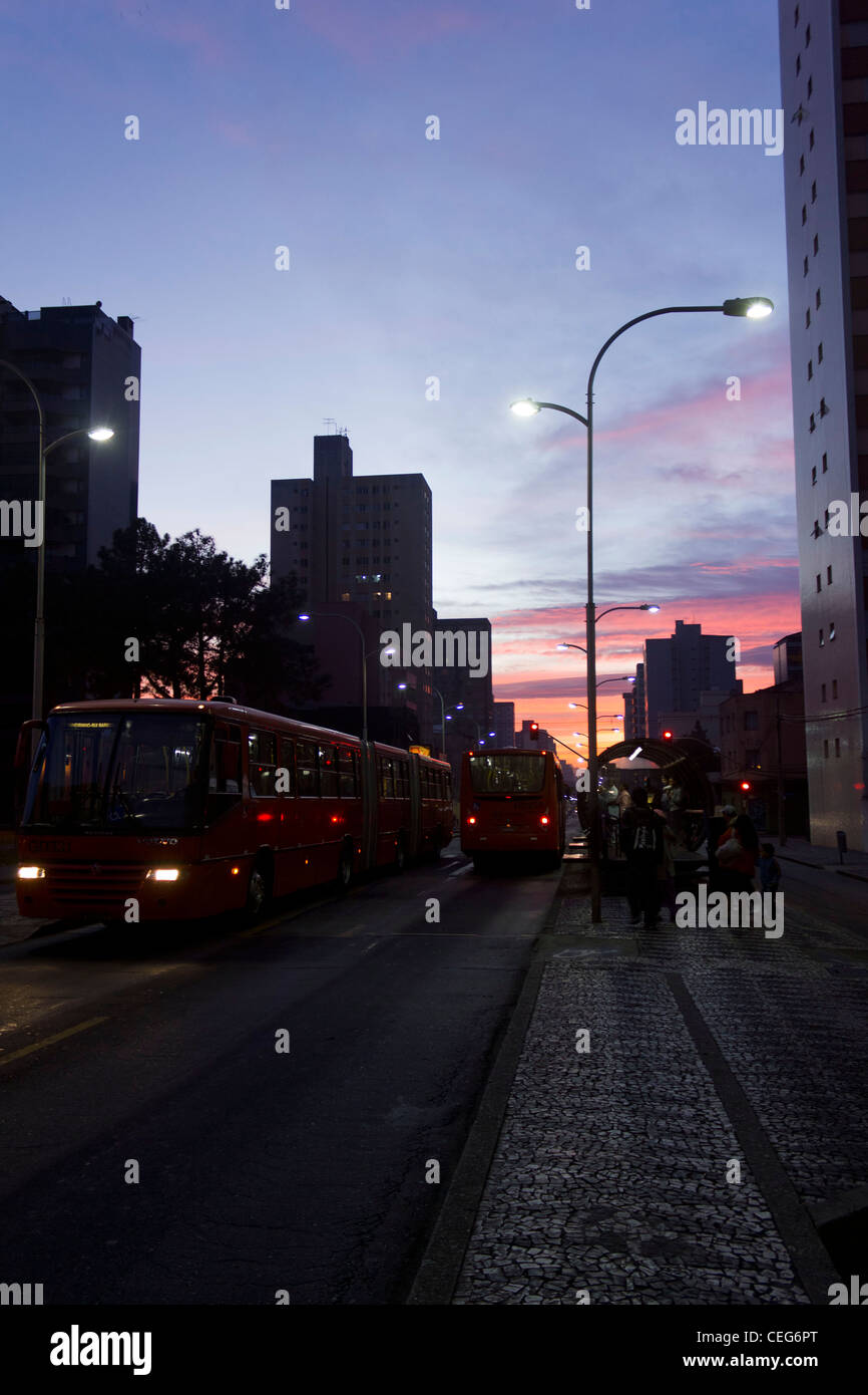 Curitiba's bus system at down. Express red bus stopping at on tube ...