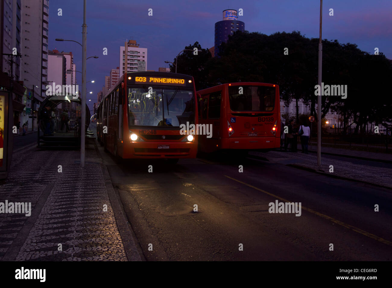 Curitiba's bus system at down. Express red bus stopping at on tube ...