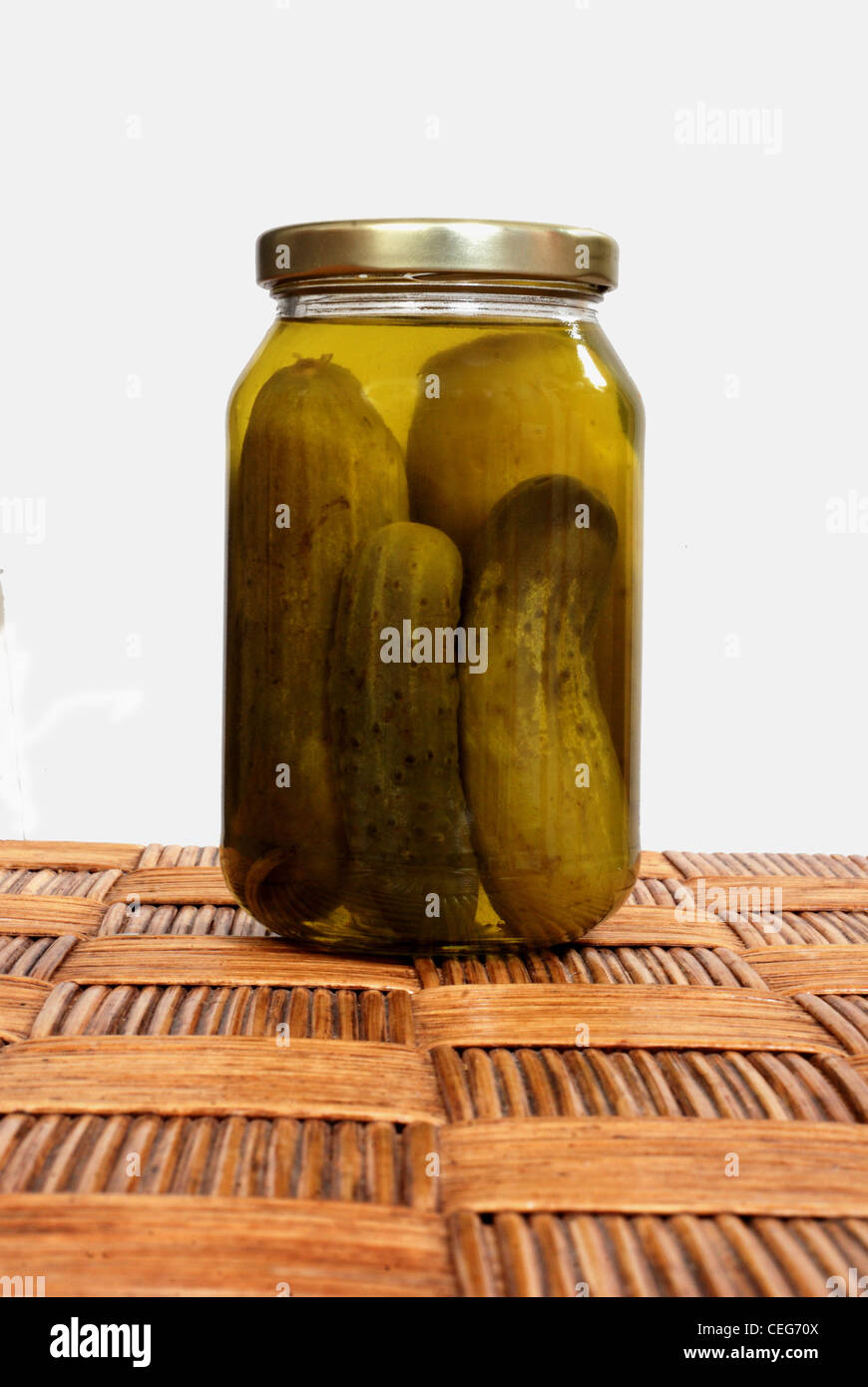 A single jar of pickles sitting on a wicker table. On white background ...
