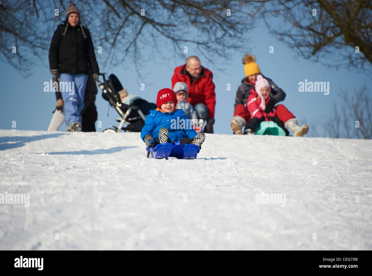 A children sledding downhill winter Stock Photo - Alamy