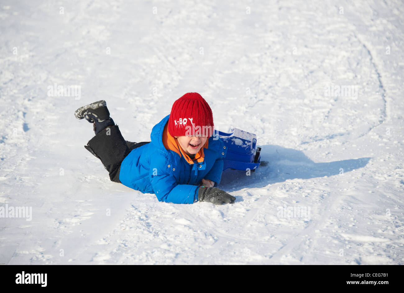 A child little boy sledding downhill winter Stock Photo - Alamy