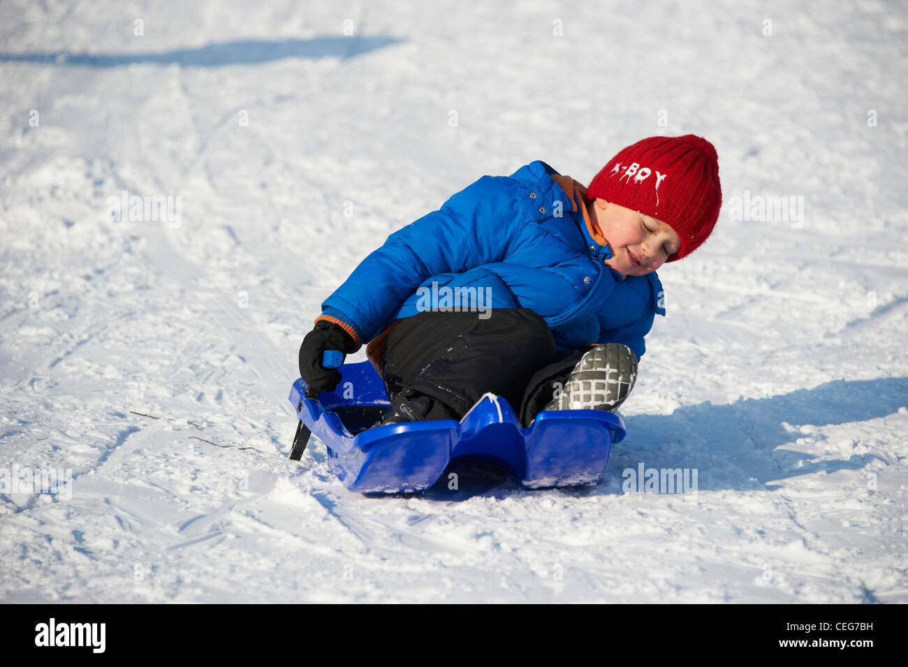 A child little boy sledding downhill winter Stock Photo - Alamy