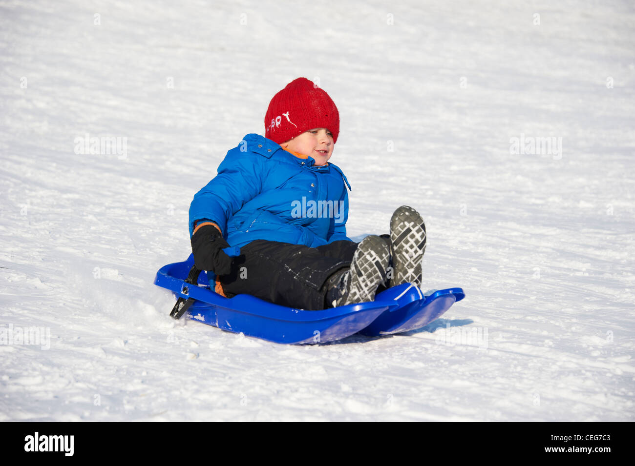 A child little boy sledding downhill winter Stock Photo - Alamy