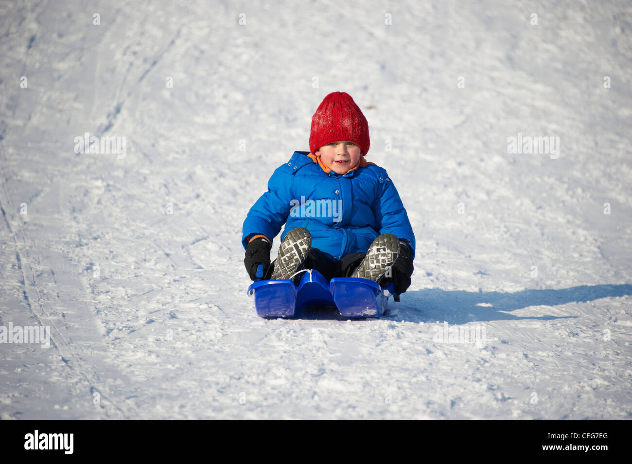 A child little boy sledding downhill winter Stock Photo - Alamy