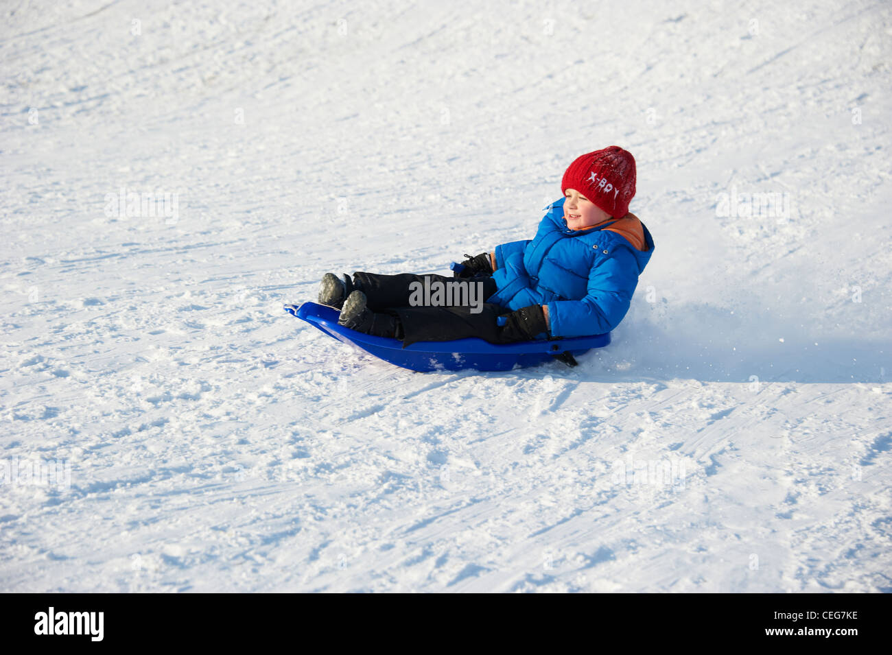 A child little boy sledding downhill winter Stock Photo - Alamy