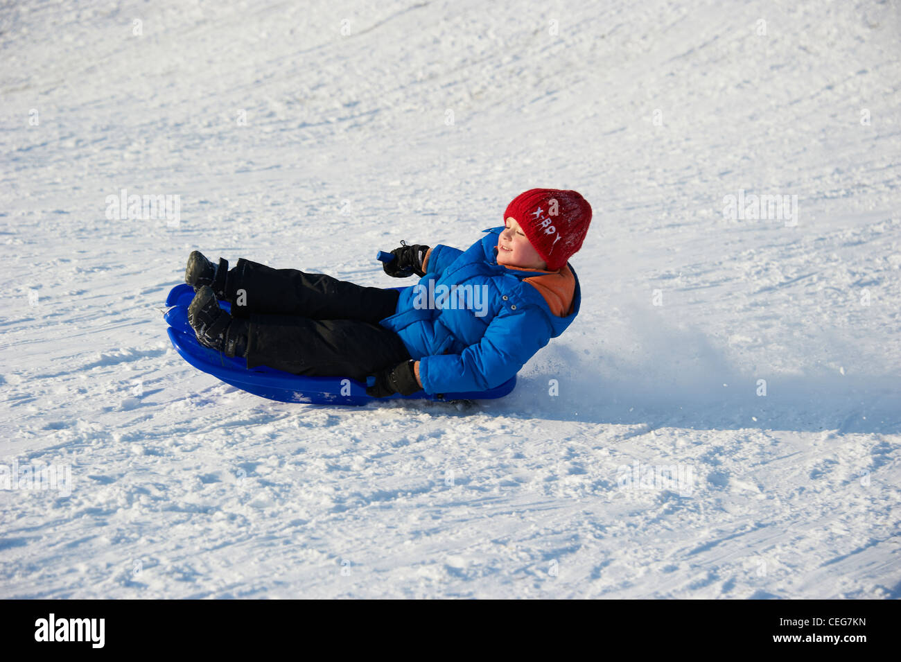A child little boy sledding downhill winter Stock Photo - Alamy
