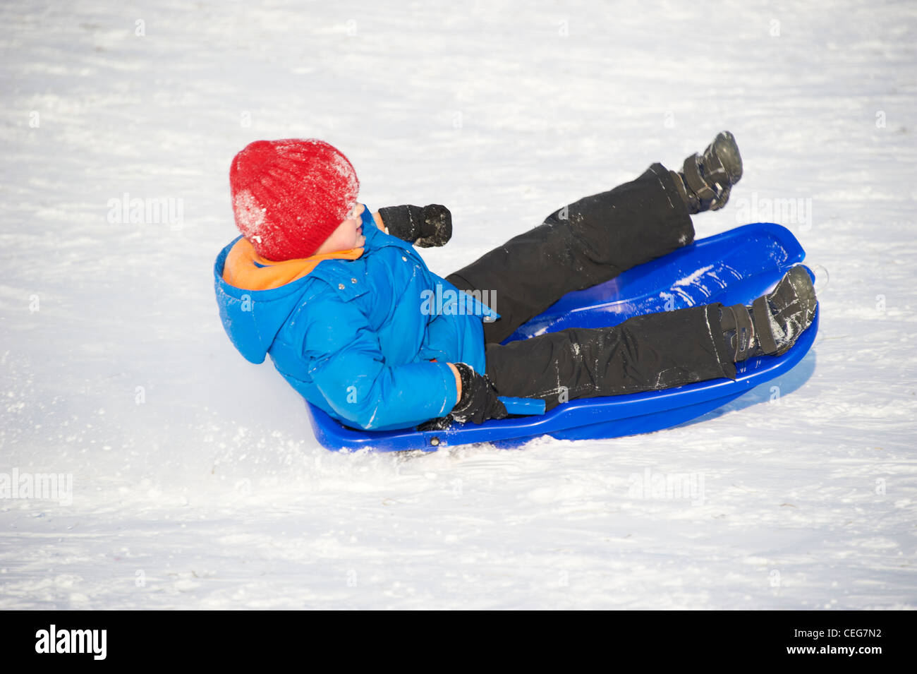A child little boy sledding downhill winter Stock Photo - Alamy