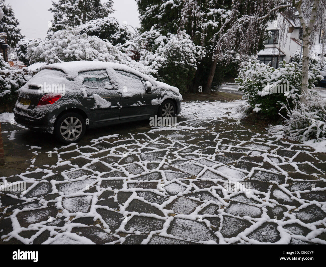 snow makes a pretty pattern on tiled driveway of house with snow ...