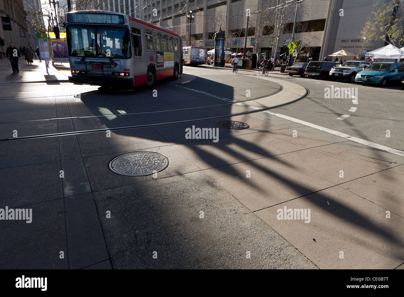 A San Francisco electric trolley bus with the sun behind casting a long ...