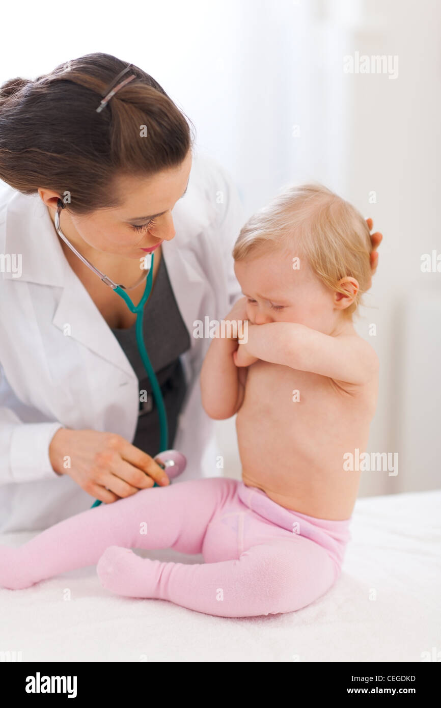 Pediatrician doctor calming crying baby Stock Photo - Alamy