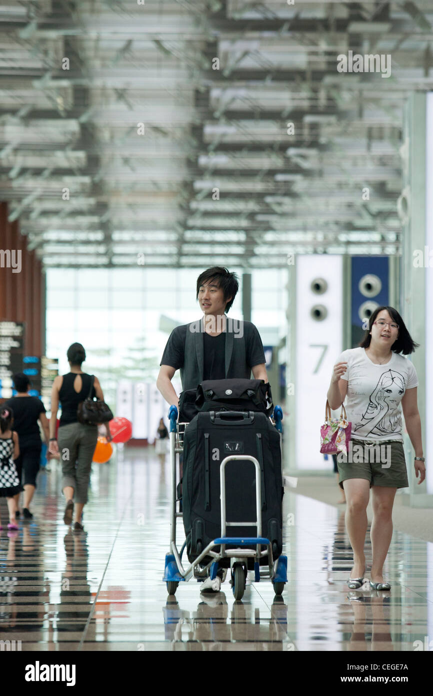 Passengers arrive to check in for a flight at Changi Airport Terminal ...